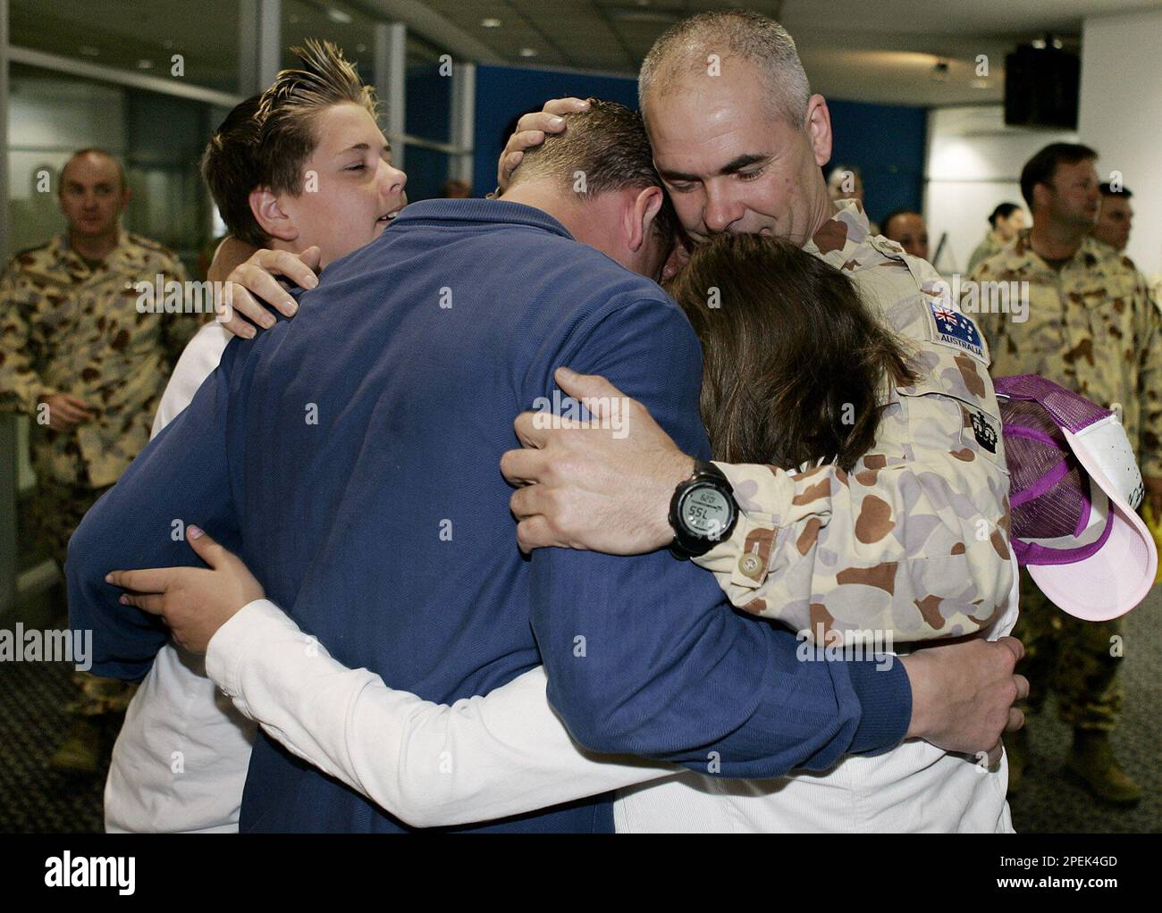 Australian Army warrant officer Tom Sullivan is embraced by his family ...