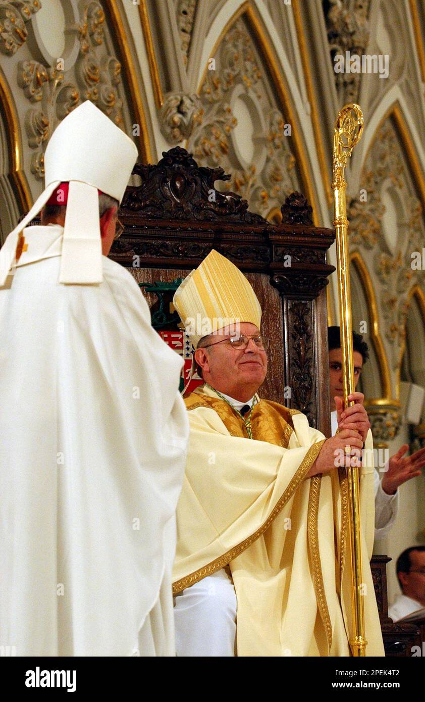 Bishop Edward Kmiec, seated, accepts the pastoral staff as Archbishop ...