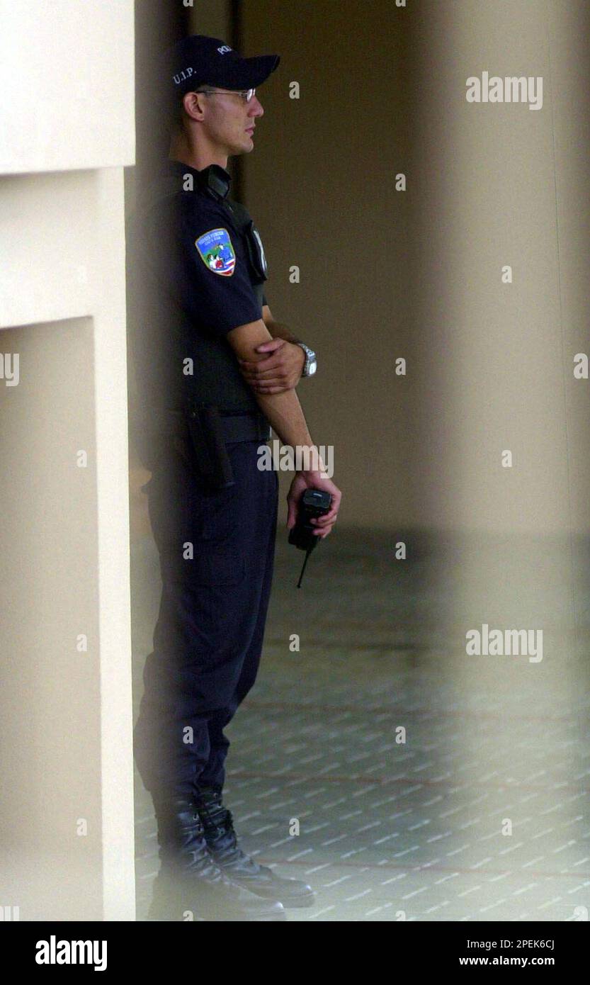 A Costa Rican police officer stands guard outside the apartments where ...