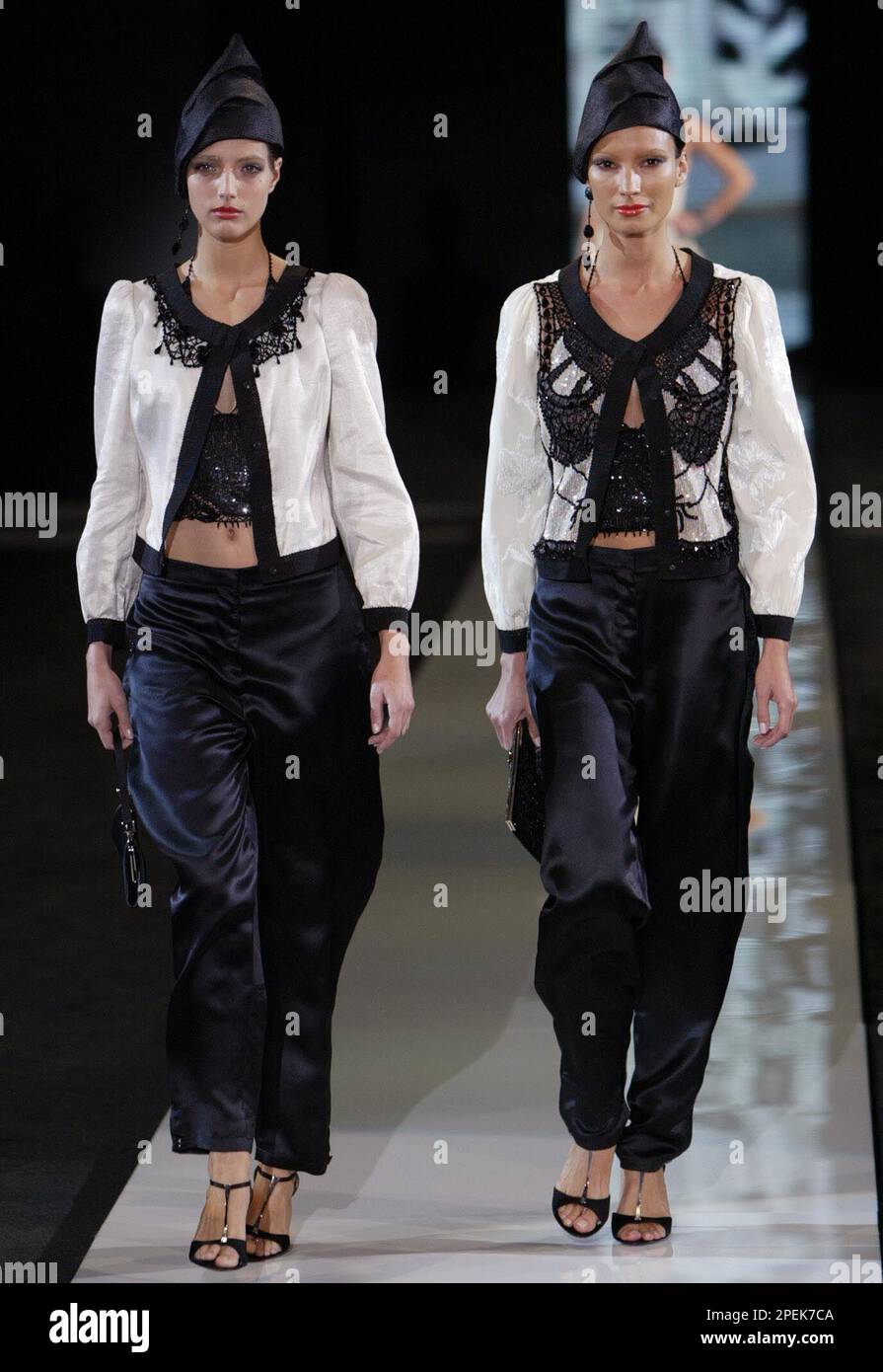 Two models walk the runway in open blouses with lace, silk, and bead ...