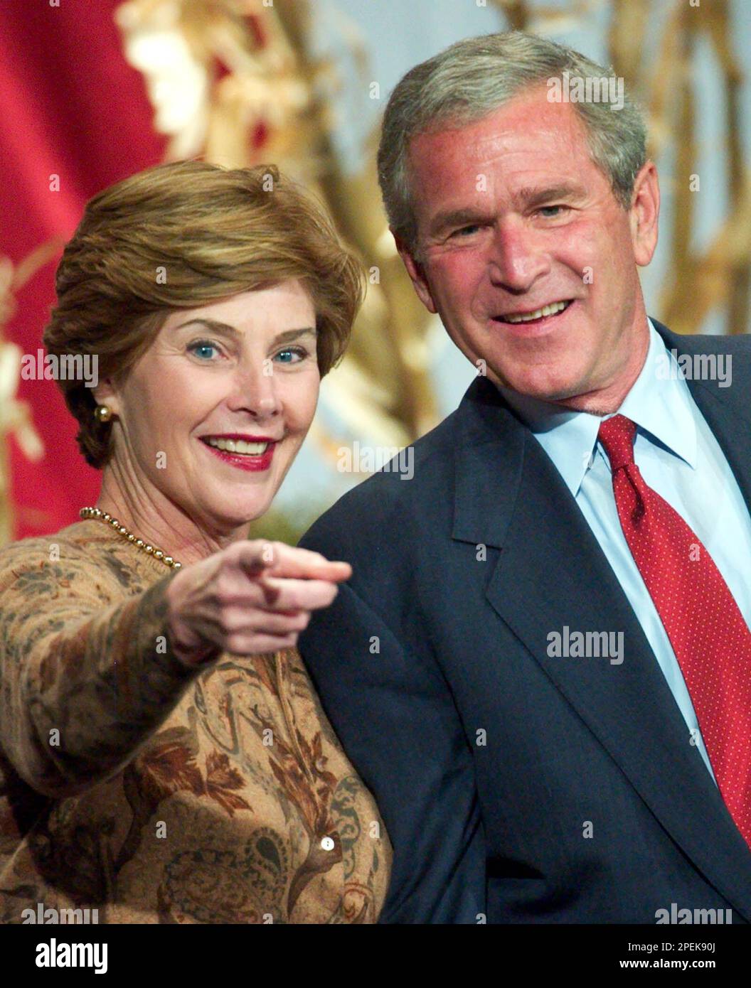 First lady Laura Bush points out people in the crowd to her husband ...