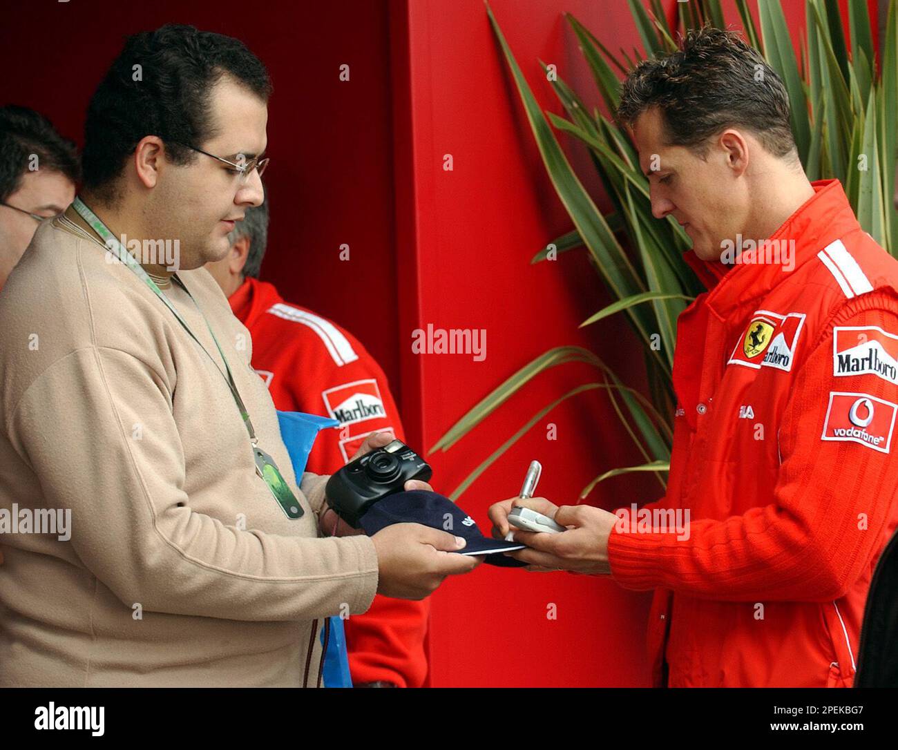 German Michael Schumacher, right, of Ferrari signs an autograph to a ...