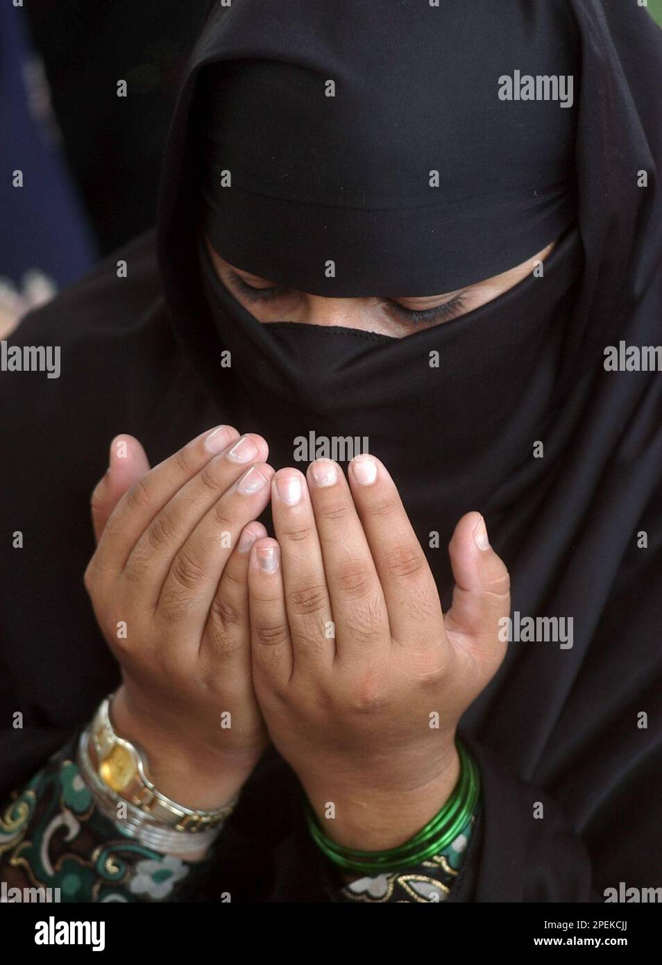 A Pakistani woman prays after the first Friday prayers of the Islamic ...