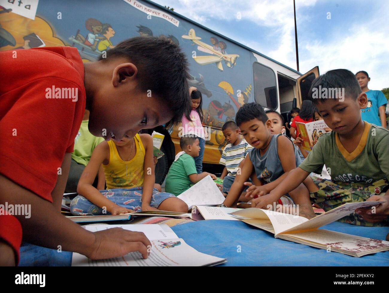 Poor Filipino kids read books outside a "Mobile Library" at Manila's ...