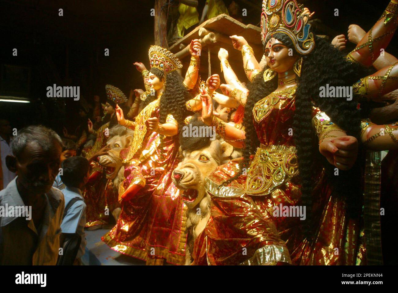 Devotees look at statues of Hindu Goddess Durga at a makeshift prayer ...