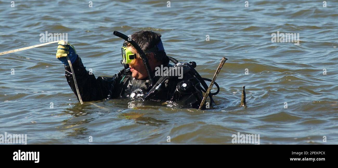 Volunteer diver Tim Jeffas of Leonardstown, Md., holds a measuring tape ...