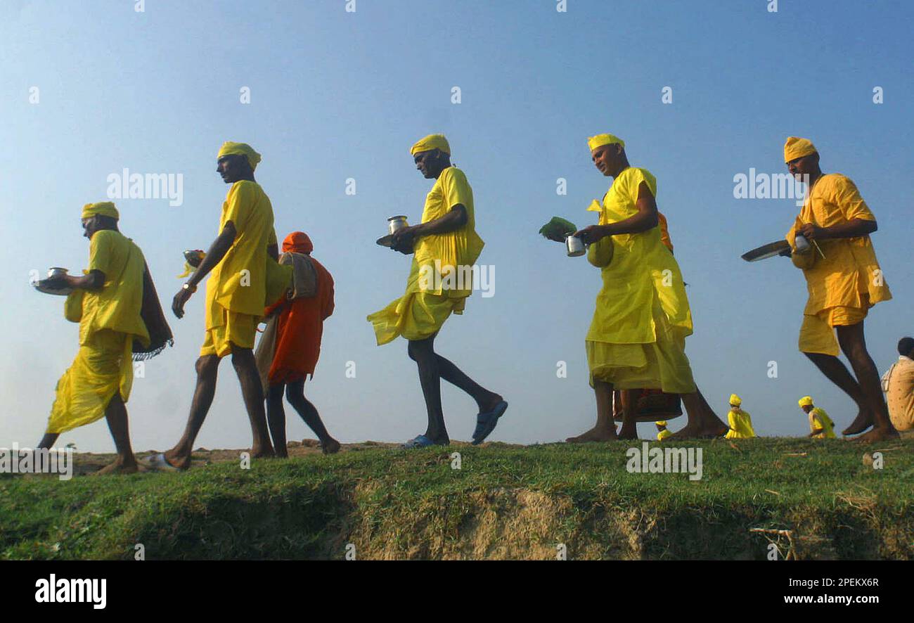 Hindu devotees walk towards the River Ganga to make offerings as part ...