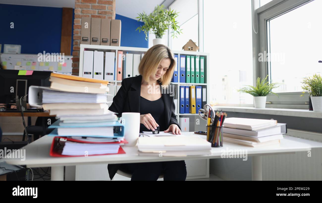 Businesswoman or secretary in office and stamping document Stock Photo ...