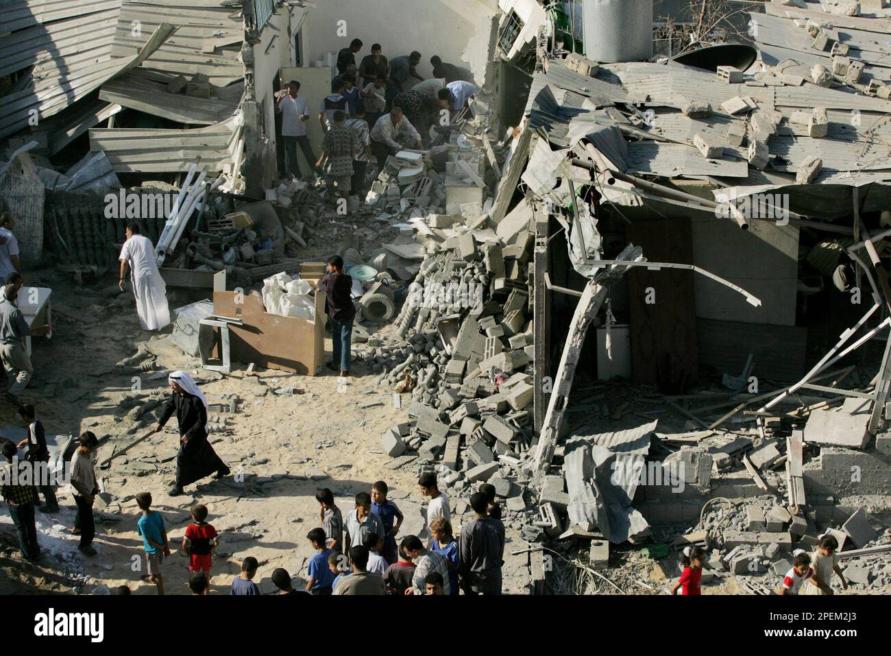 Palestinian residents gather in the rubble following an Israeli missile ...