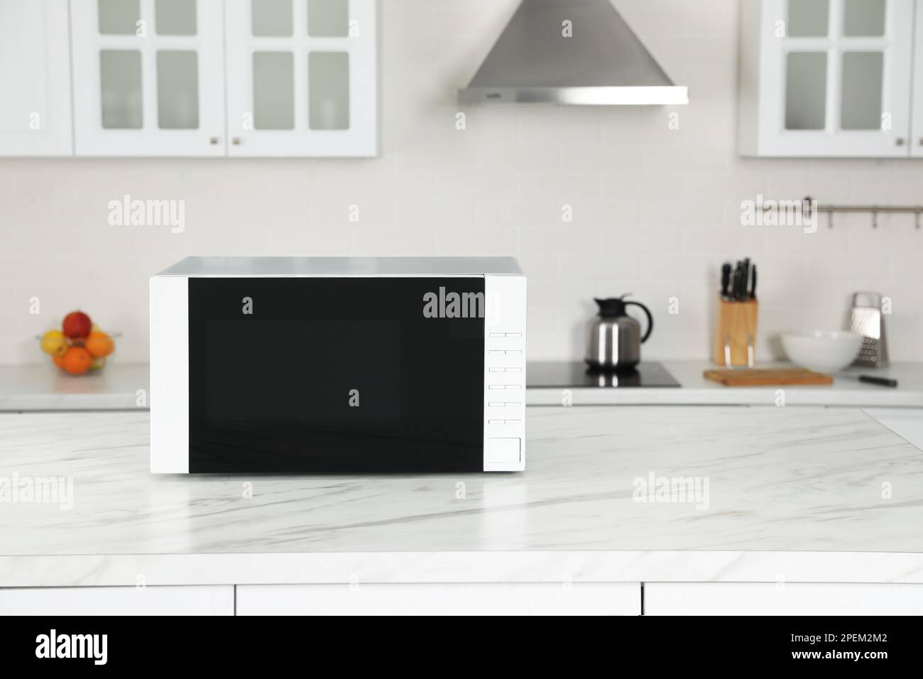Modern microwave oven on white table in kitchen, space for text Stock ...
