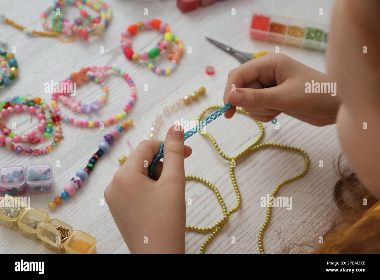 Hands of a child making jewelry hi-res stock photography and images - Alamy