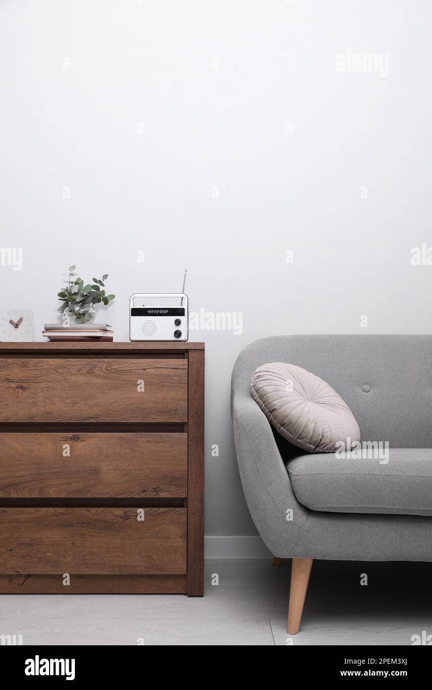 Stylish white radio on wooden cabinet in living room interior. Space ...