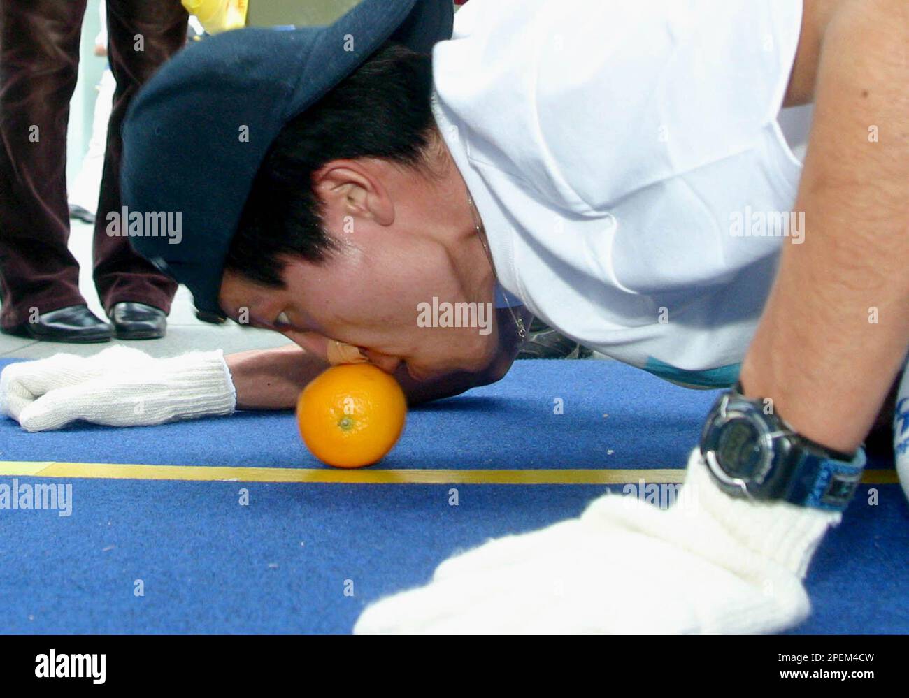 Jamie Ng, a constestant, keeps his nose on an orange as he takes part ...
