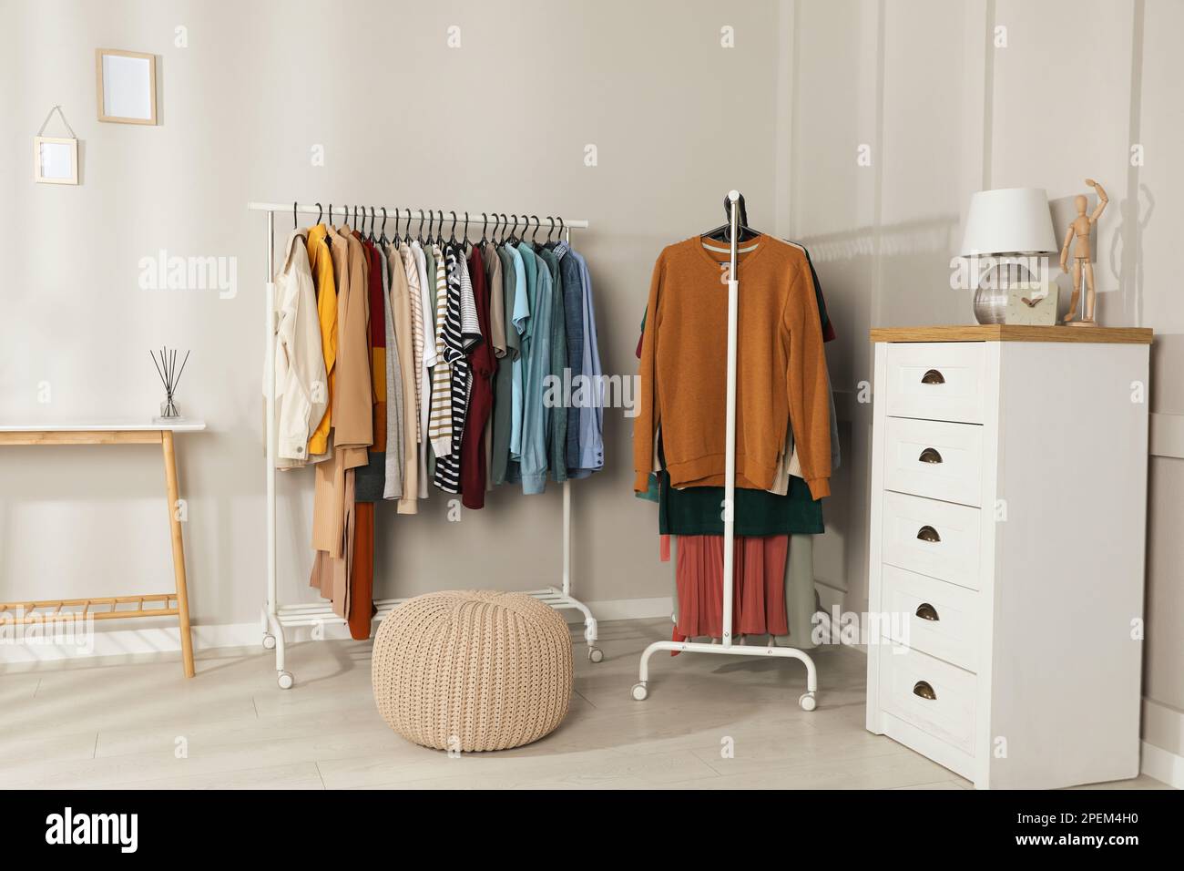 Racks with stylish clothes in cozy room interior. Fast fashion Stock ...
