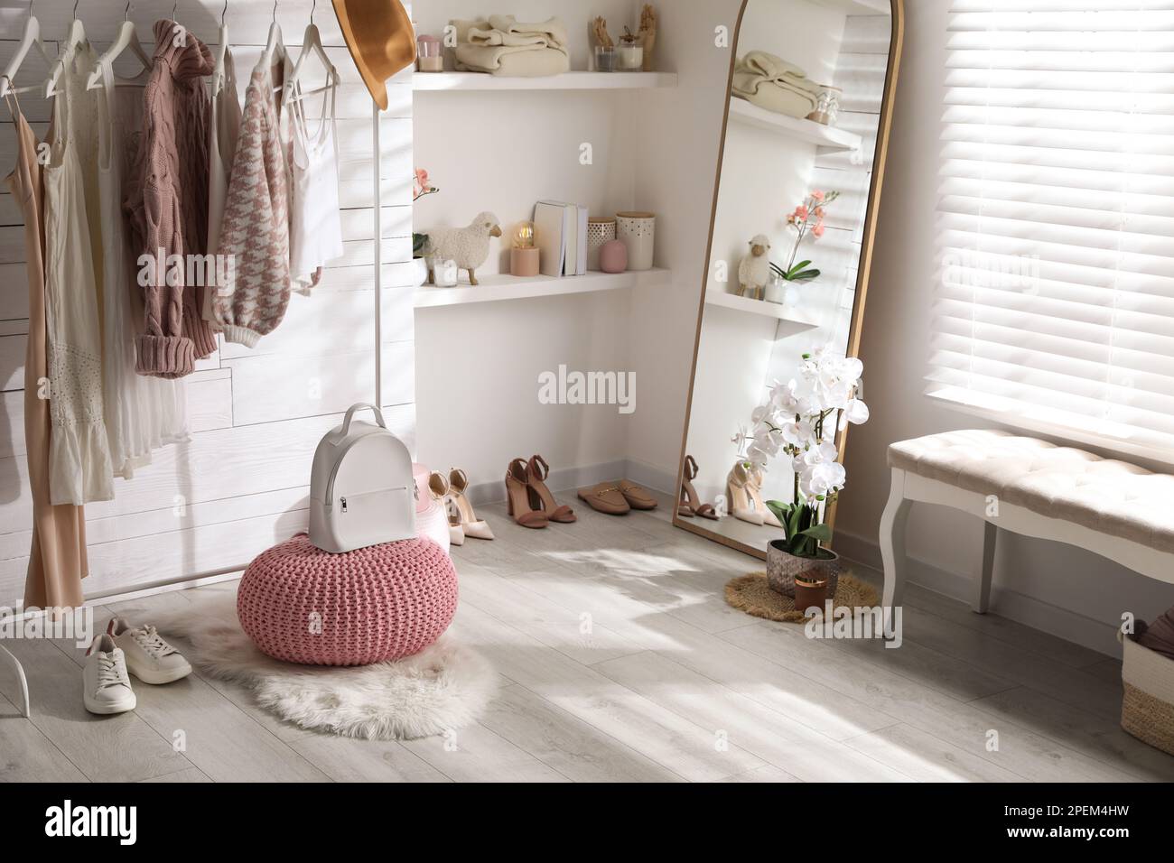 Rack with different stylish clothes, shoes and decorative elements in ...