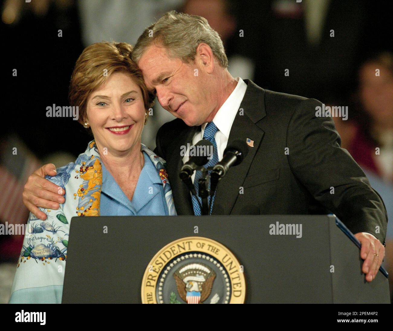 President Bush shares a moment with his wife Laura as the crowds cheer ...