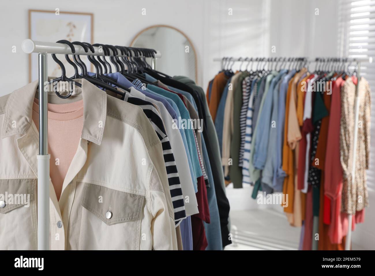 Racks with stylish clothes indoors. Fast fashion Stock Photo - Alamy