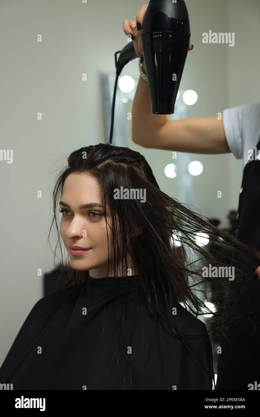 Hairdresser drying woman's hair in beauty salon Stock Photo - Alamy