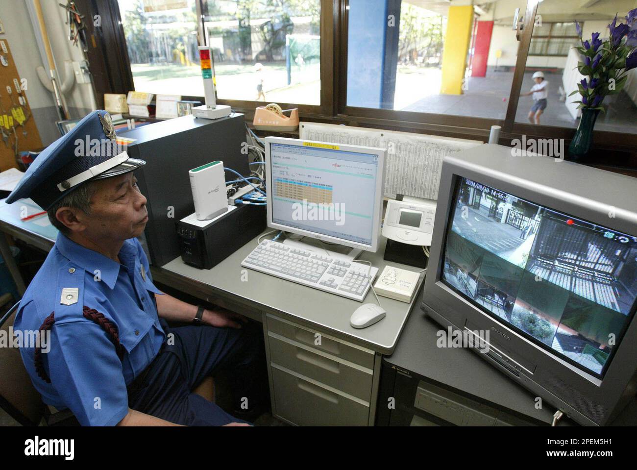 A private security guard watches a monitor showing gates and othersited ...