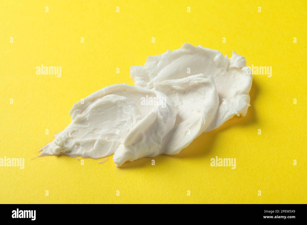 Smear of delicious cream cheese on yellow background Stock Photo - Alamy