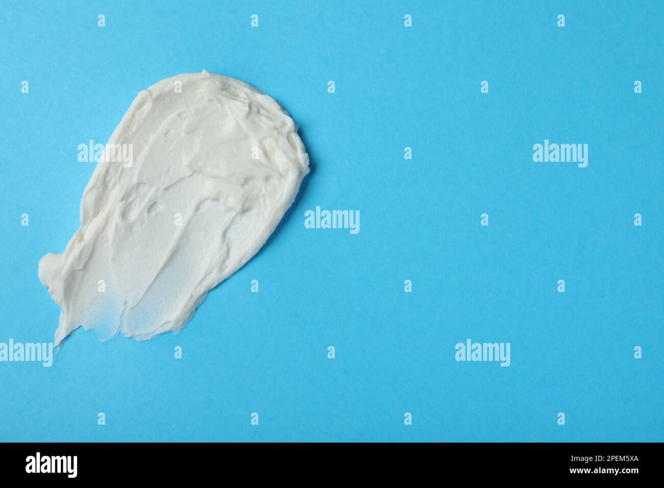 Smear of delicious cream cheese on light blue background, top view ...