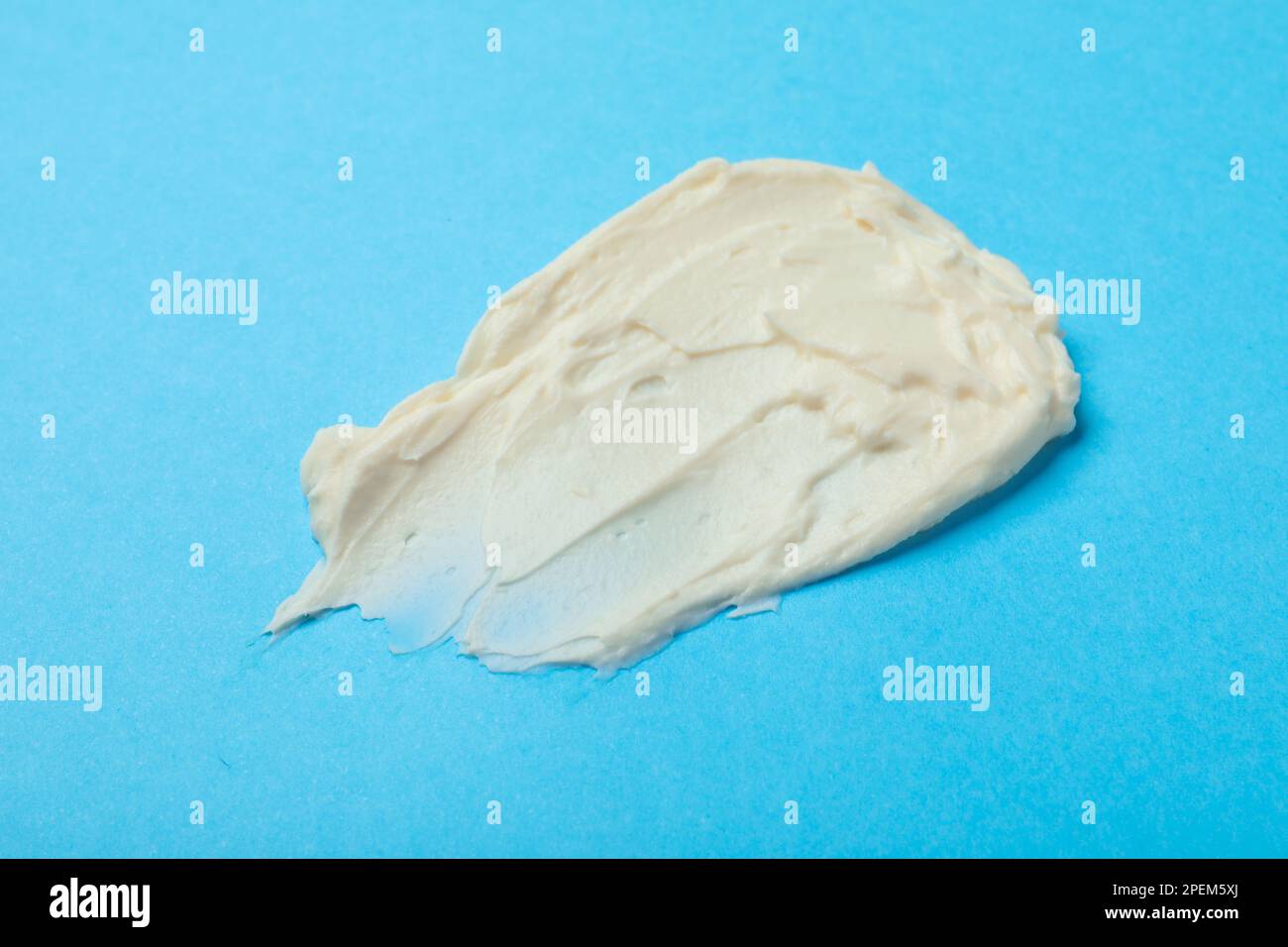 Smear of delicious cream cheese on light blue background, top view ...