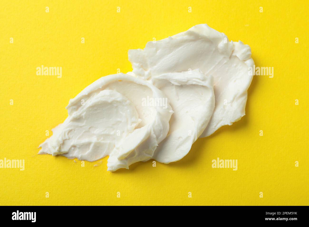 Smear of delicious cream cheese on yellow background, top view Stock ...
