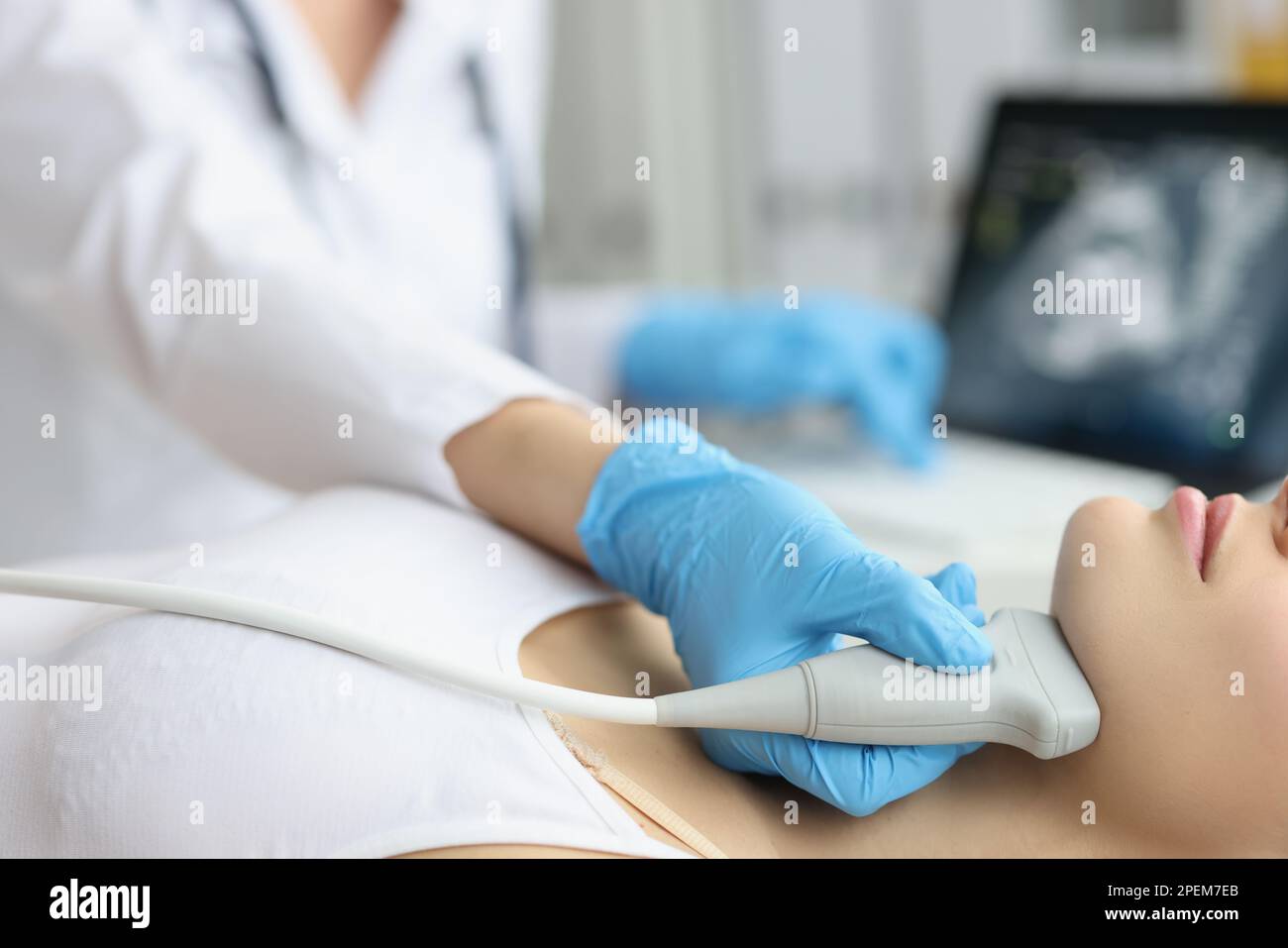 Doctor examining thyroid of female patient with ultrasound scan in ...