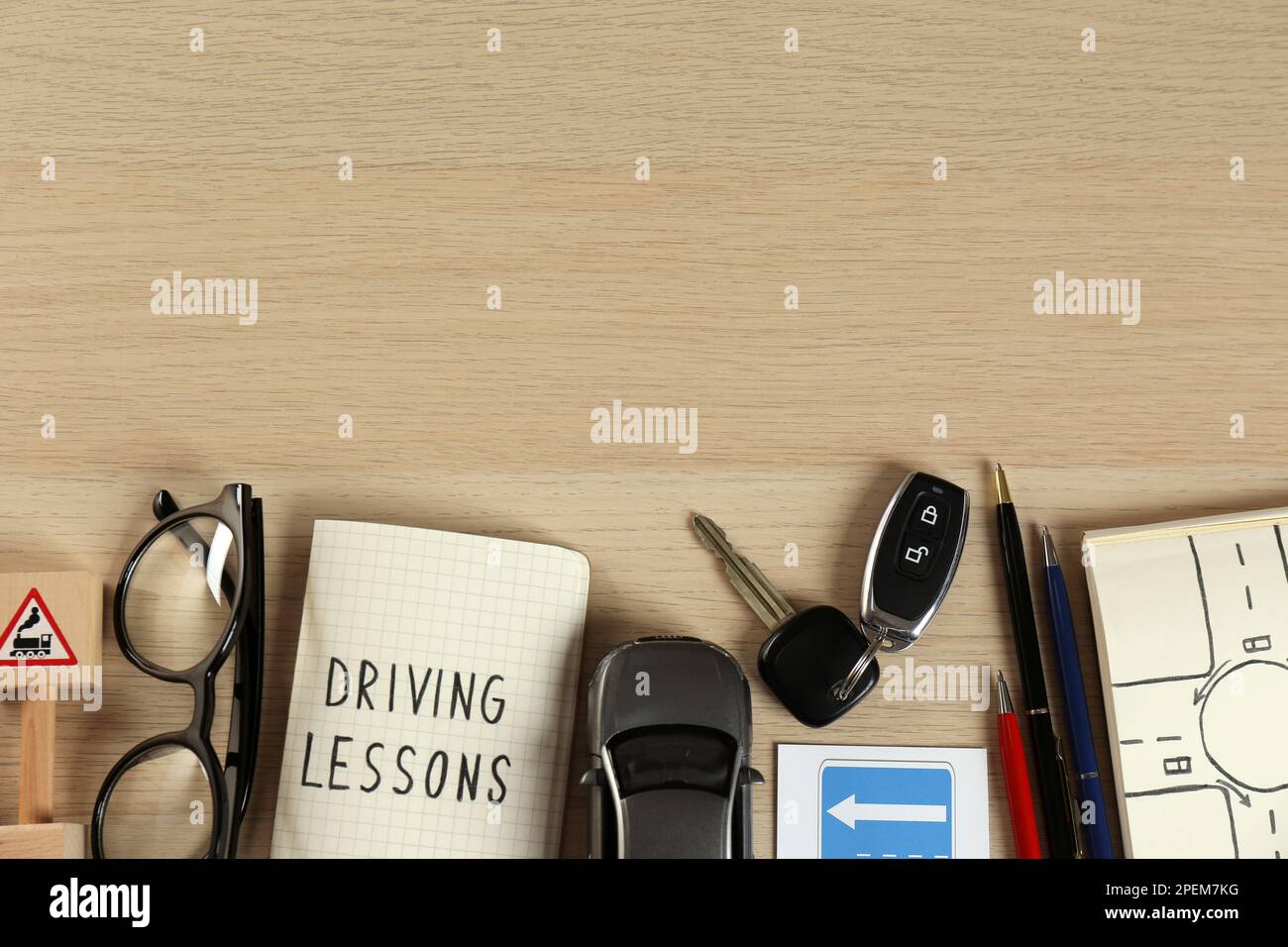 Flat lay composition with driving lessons workbook and toy car on ...