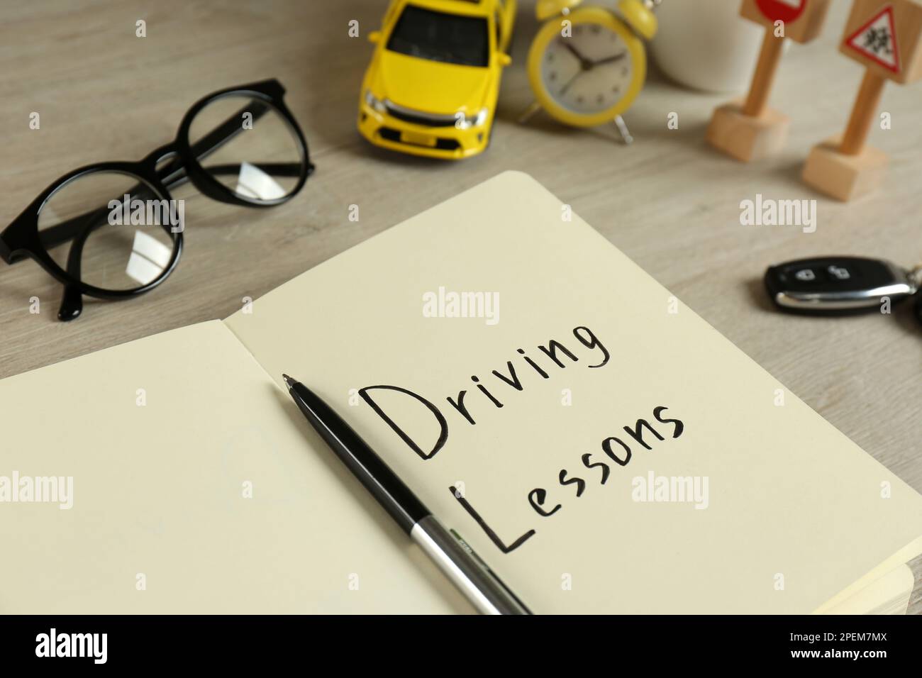 Workbook for driving lessons with pen on wooden table, closeup. Passing ...
