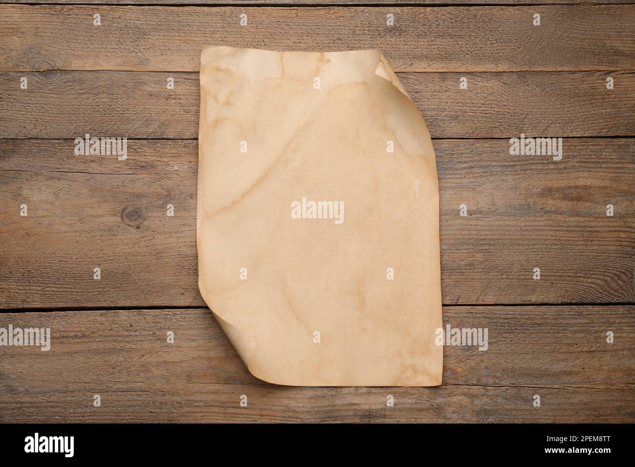 Sheet of old parchment paper on wooden table, top view. Space for ...