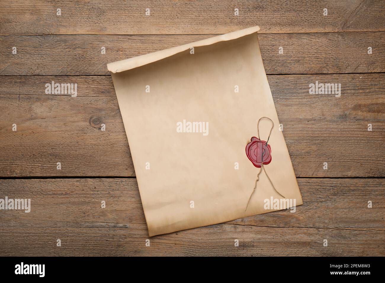 Sheet of old parchment paper with wax stamp on wooden table, top view ...