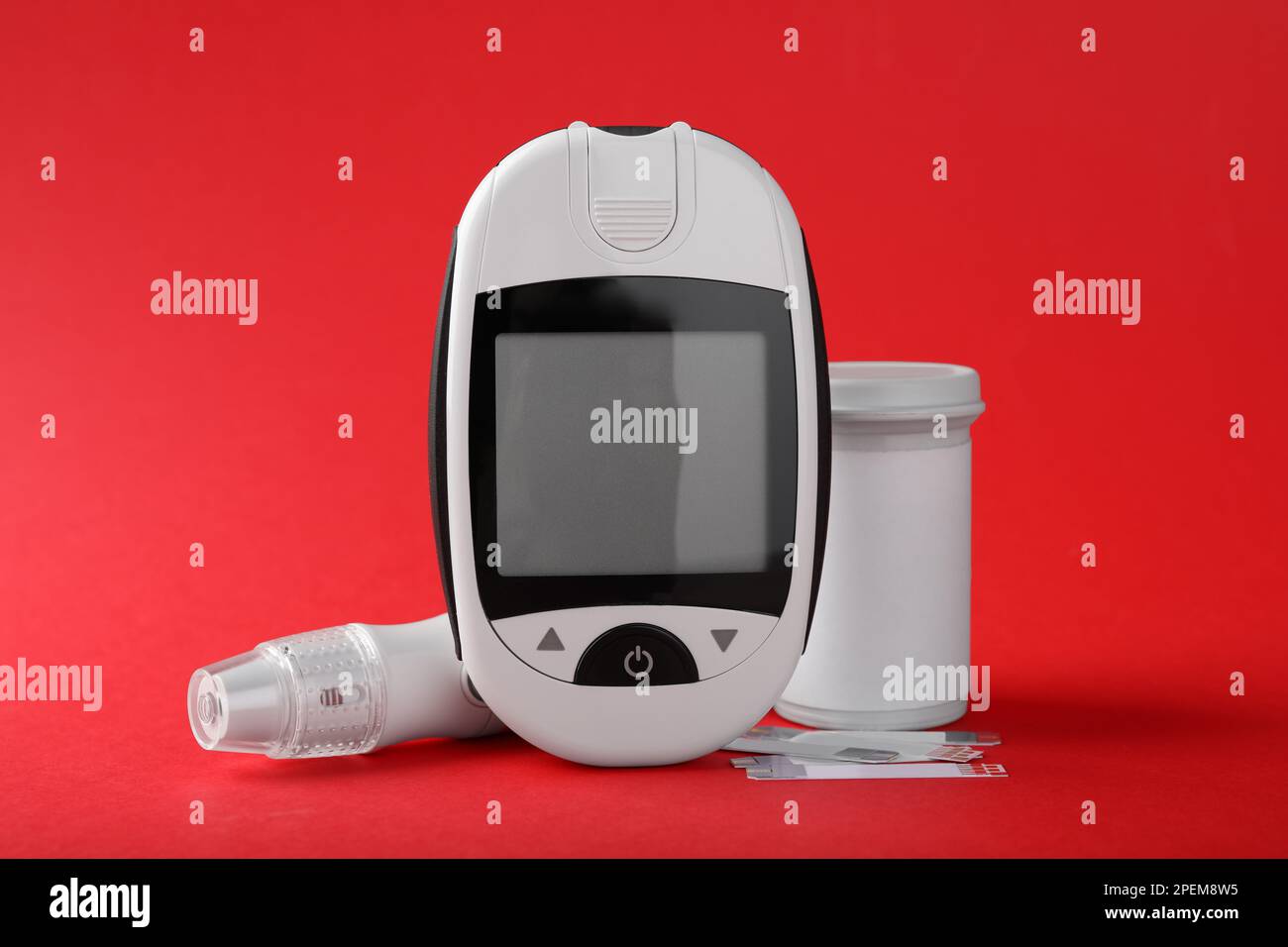 Digital glucometer, lancet pen and test strips on red background ...