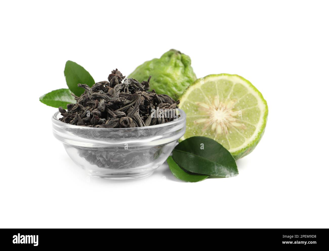 Dry bergamot tea leaves in glass bowl and fresh fruits on white ...