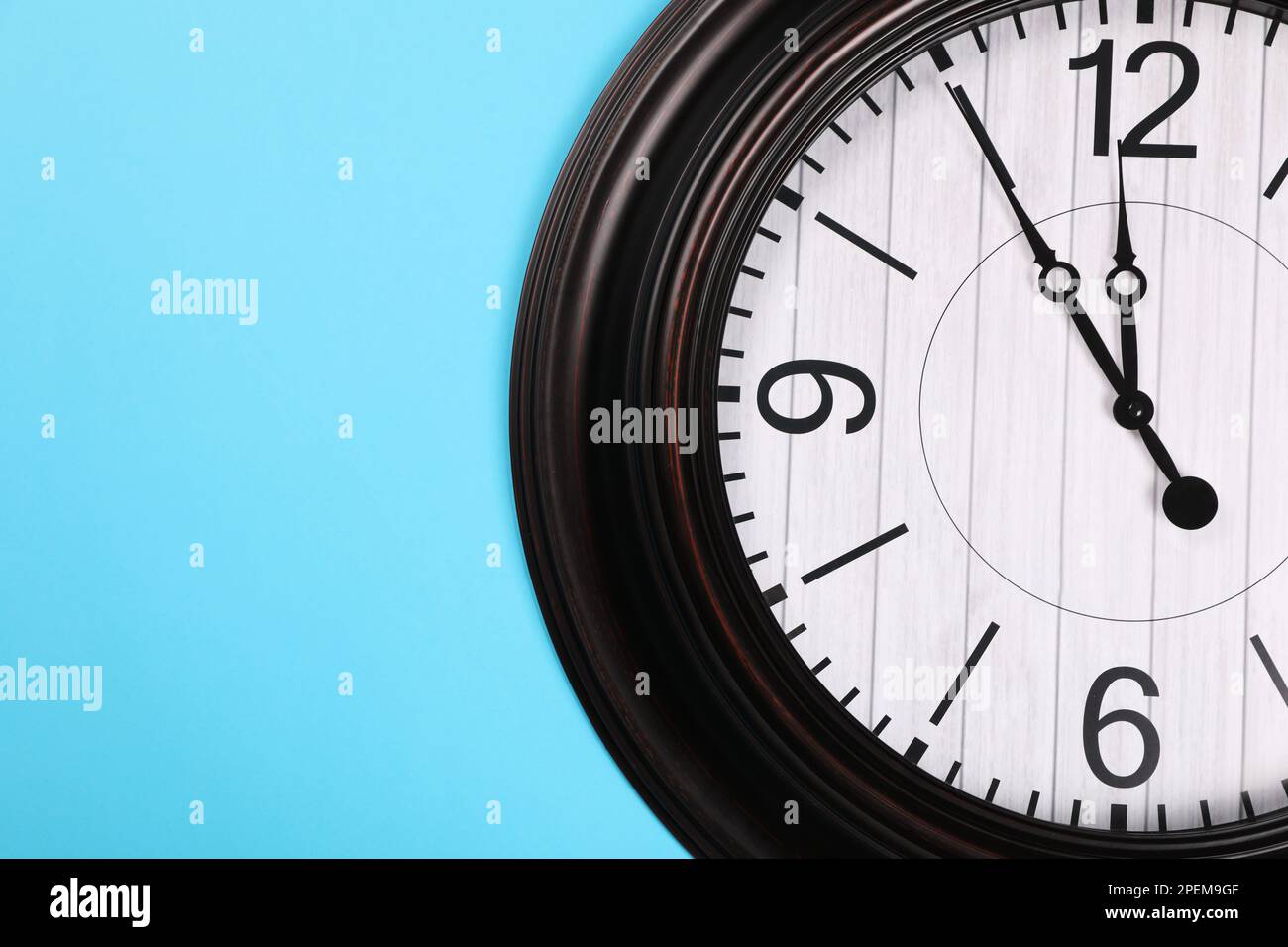 Stylish wall clock showing five minutes until midnight on turquoise ...