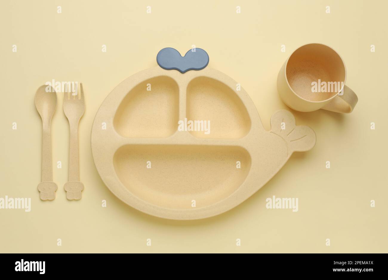 Set of plastic dishware on beige background, flat lay. Serving baby ...