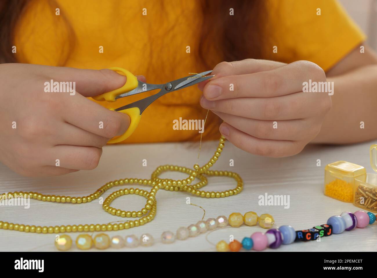 Hands of a child making jewelry hi-res stock photography and images - Alamy