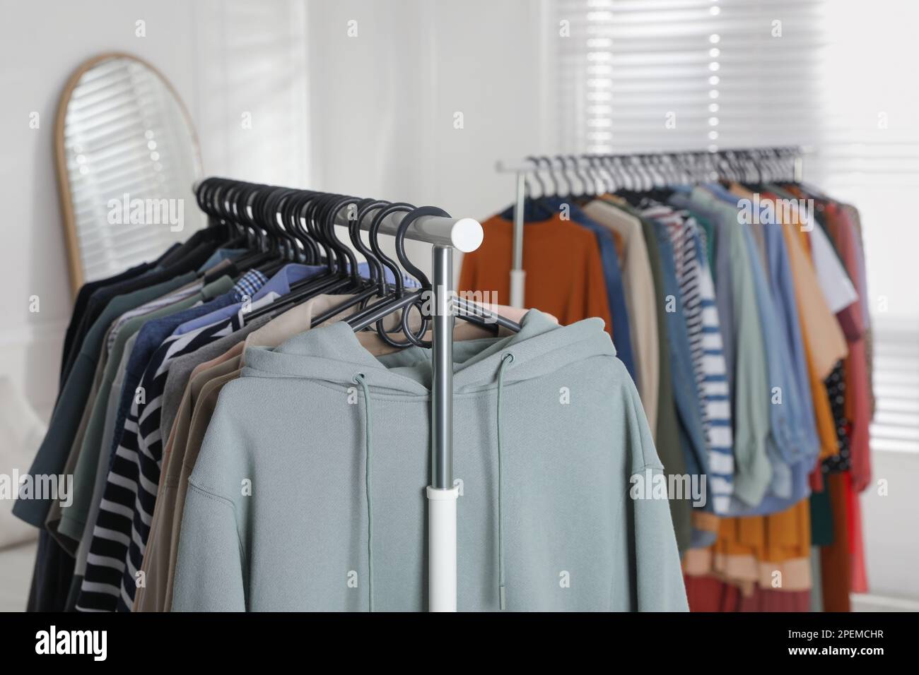 Racks with stylish clothes indoors. Fast fashion Stock Photo - Alamy