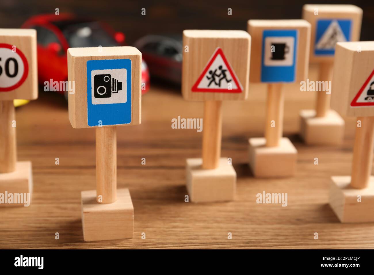 Many different miniature road signs on wooden table, closeup. Driving ...