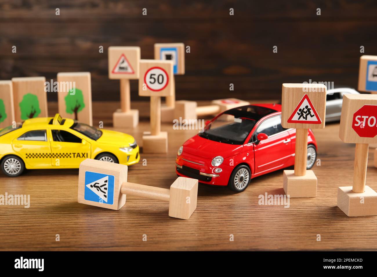 Different miniature road signs and cars on wooden table. Driving school ...
