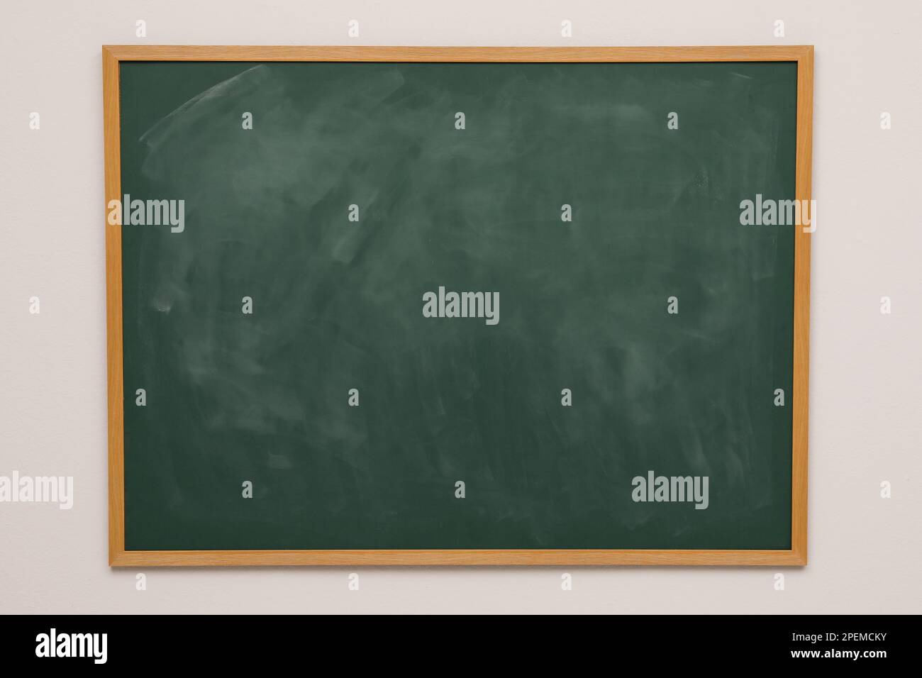 Clean green chalkboard hanging on grey wall Stock Photo - Alamy
