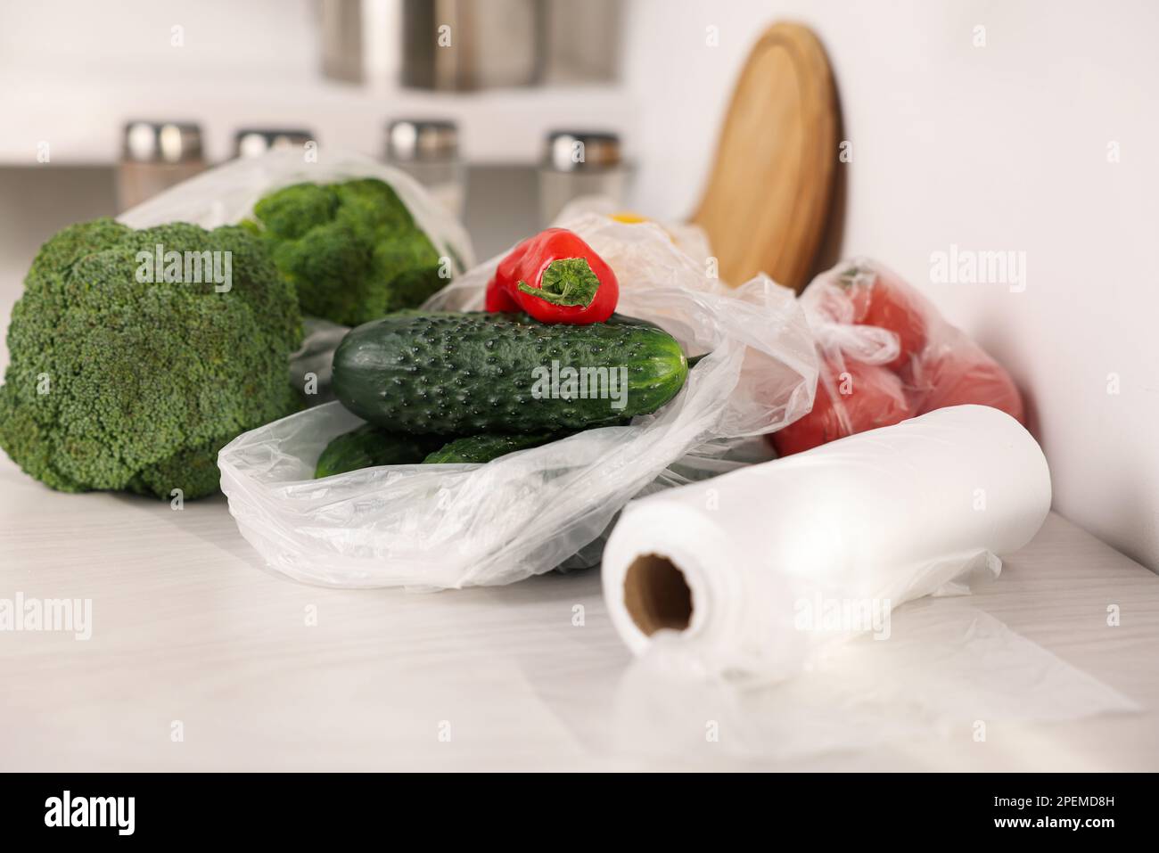 Roll of plastic bags and fresh vegetables on white table Stock Photo ...