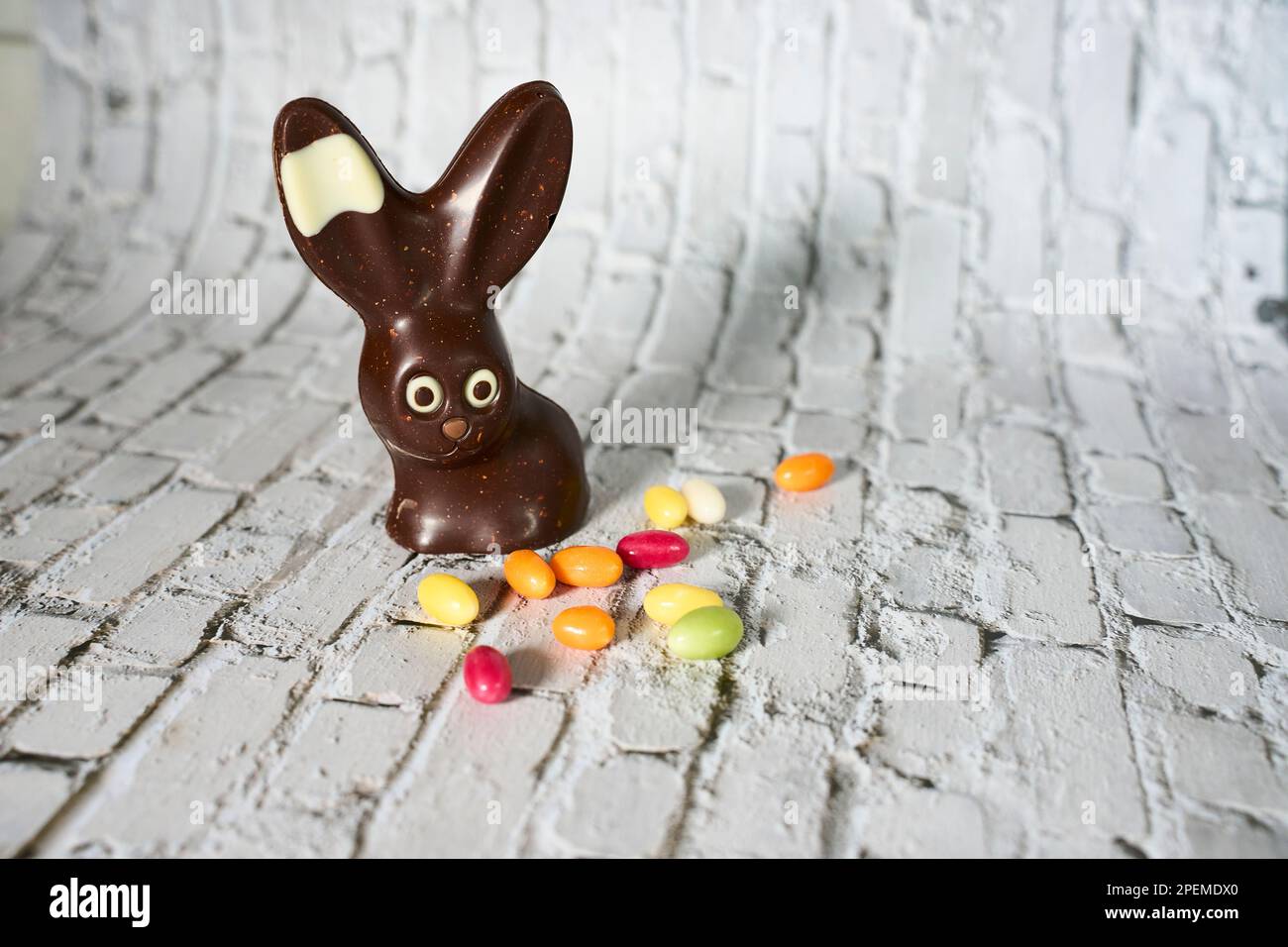 A delicious chocolate bunny on a white brick floor, surrounded by ...