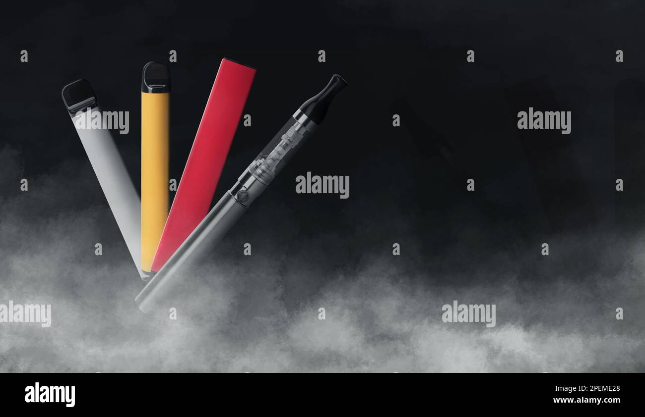 Different electronic smoking devices on black background. Space for ...
