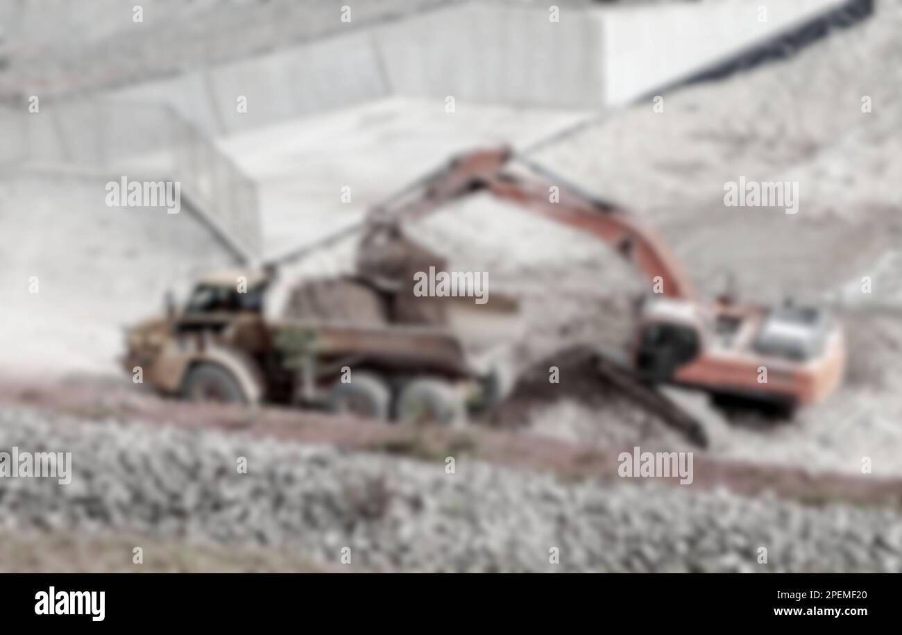 Blurred background of excavator loading material to dump truck at open ...