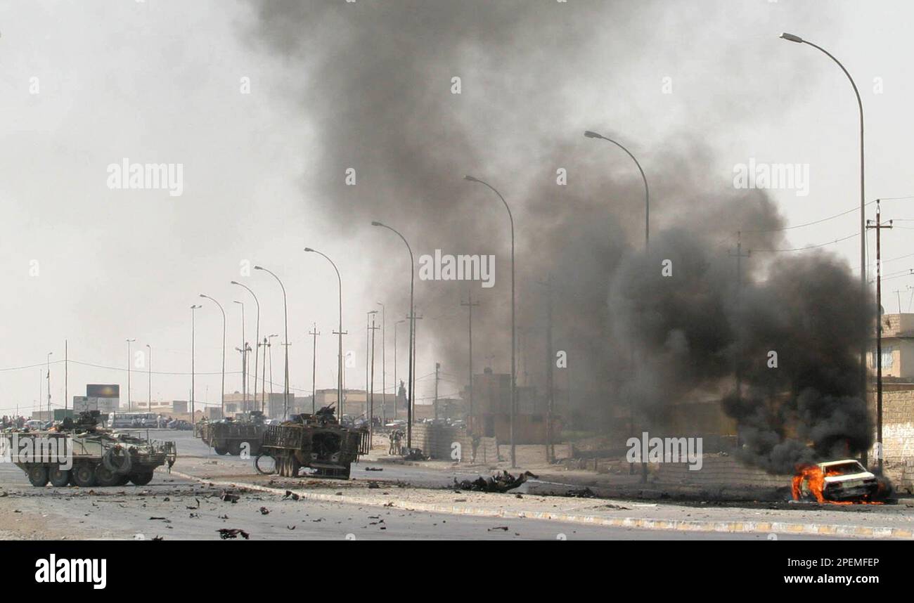 A civilian car burns after a car bomb targeting a U.S. military convoy ...