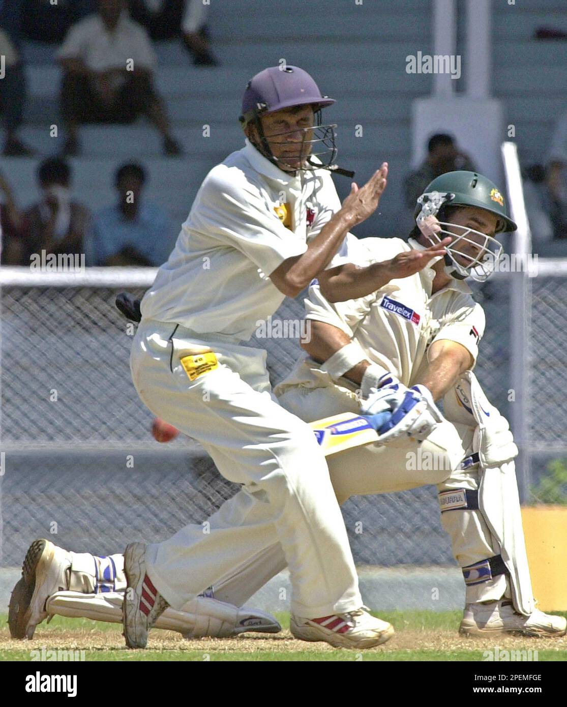 Australias Justin Langer, right, bats as Mumbai's Vinit Indulkar tries ...