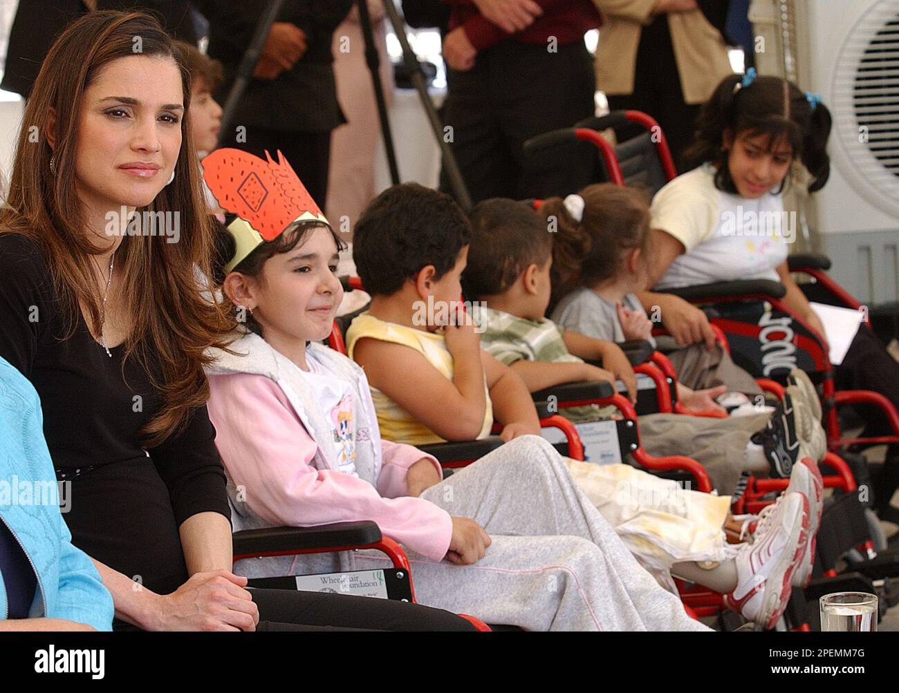Jordan's Queen Rania, left, sits with handicapped Jordanian children to ...