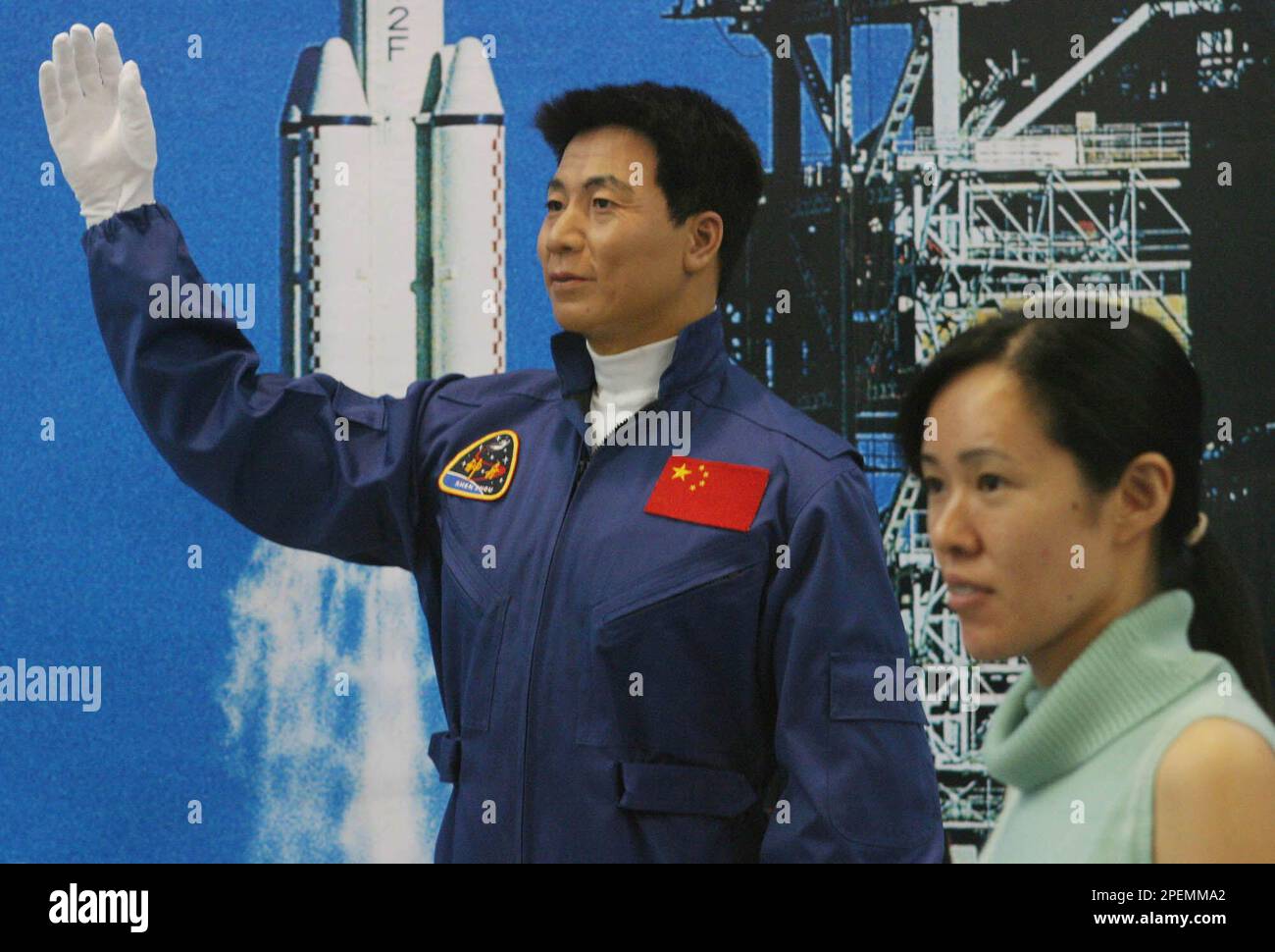 A Chinese woman poses for a picture next to a wax figure of Chinese ...