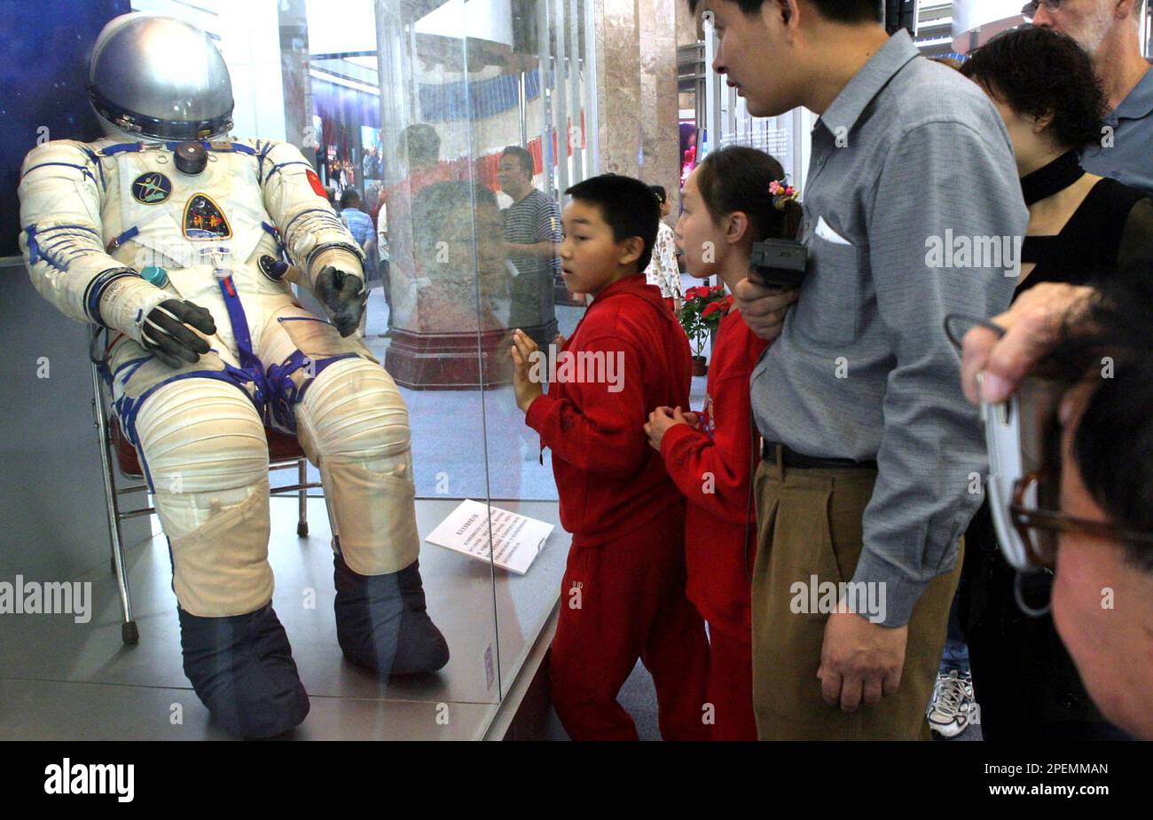 Chinese visitors look at a replica of the space suit China's first ...